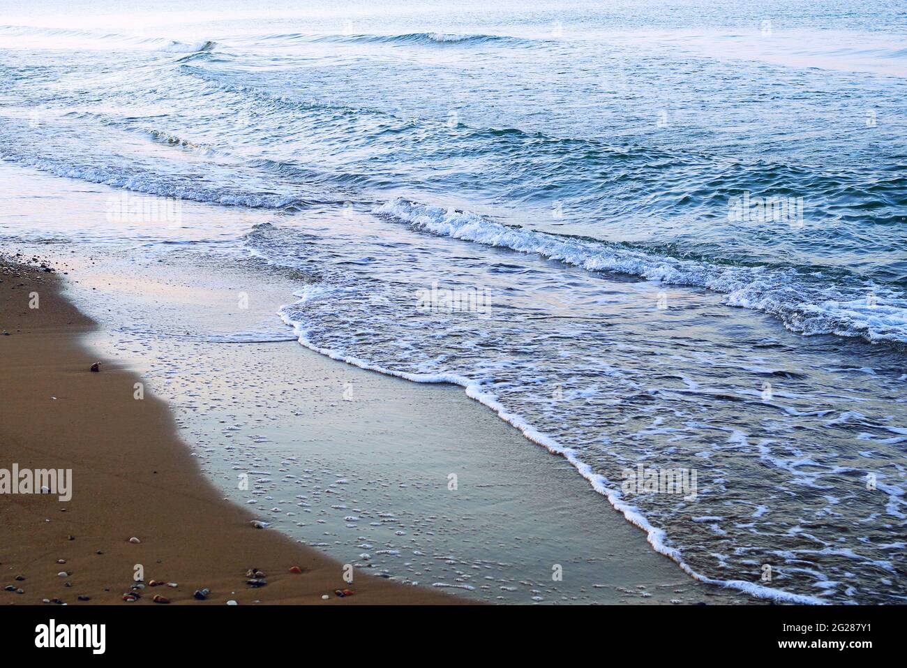 calm waves washing ashore in the morning Stock Photo - Alamy