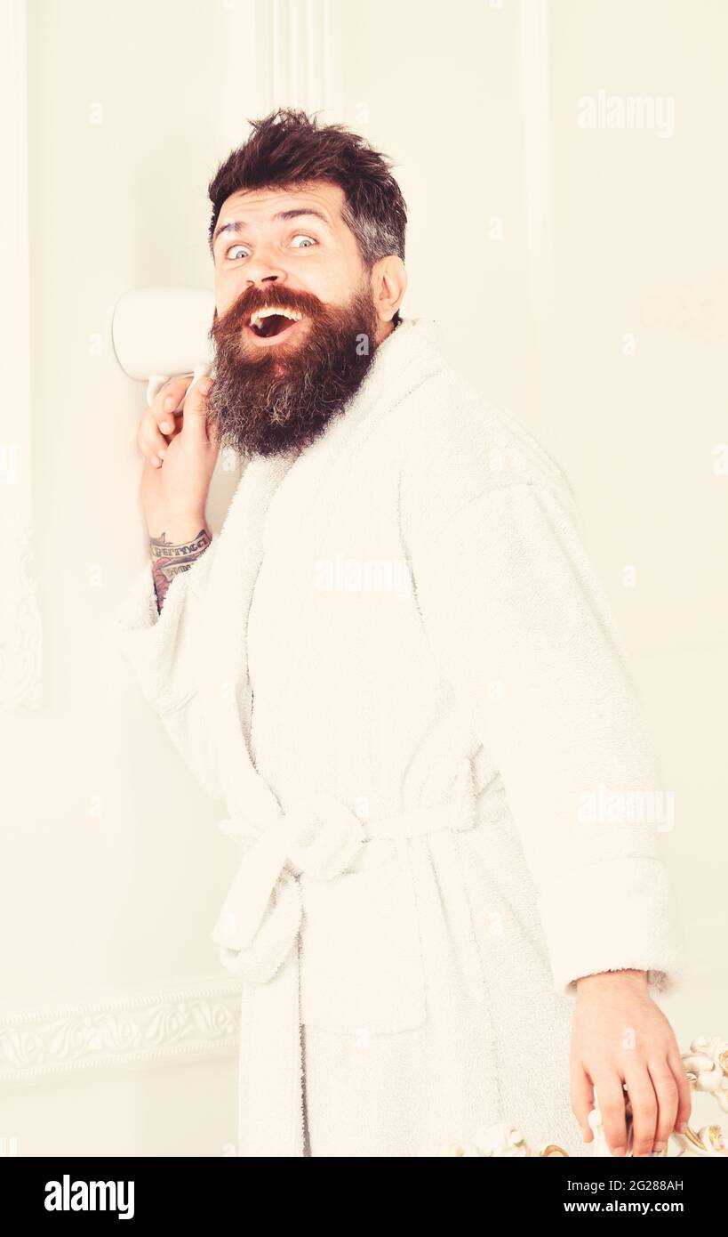 Hipster in bathrobe on surprised face secretly listen conversation ...