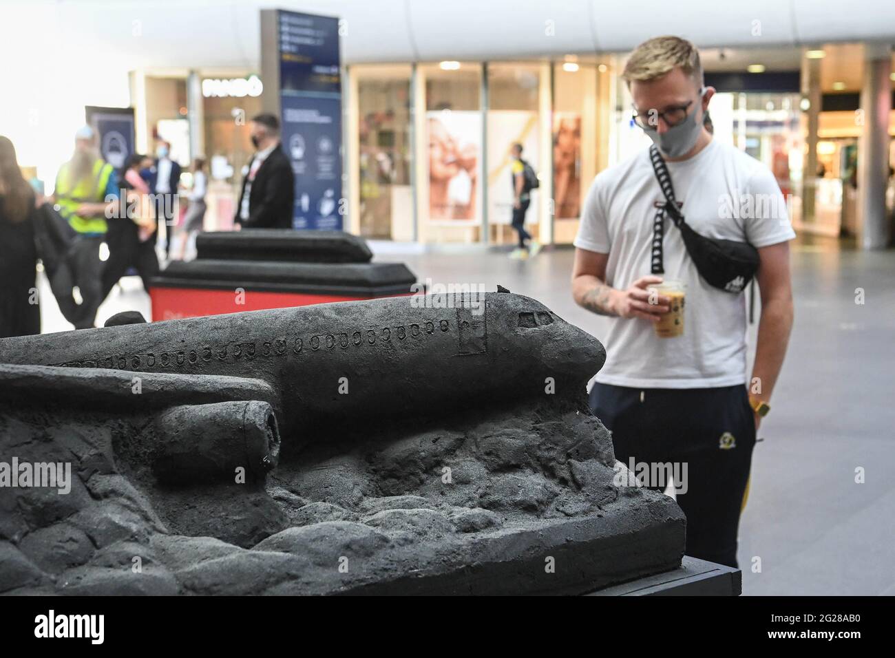 EDITORIAL USE ONLY Passers-by look at a series of sand sculptures ...