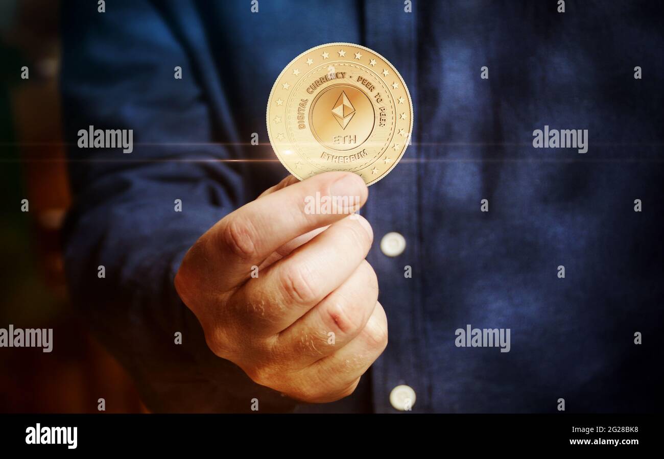 Ethereum ETH cryptocurrency symbol golden coin in hand abstract concept ...