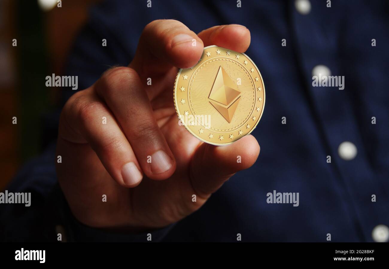 Ethereum ETH cryptocurrency symbol golden coin in hand abstract concept ...