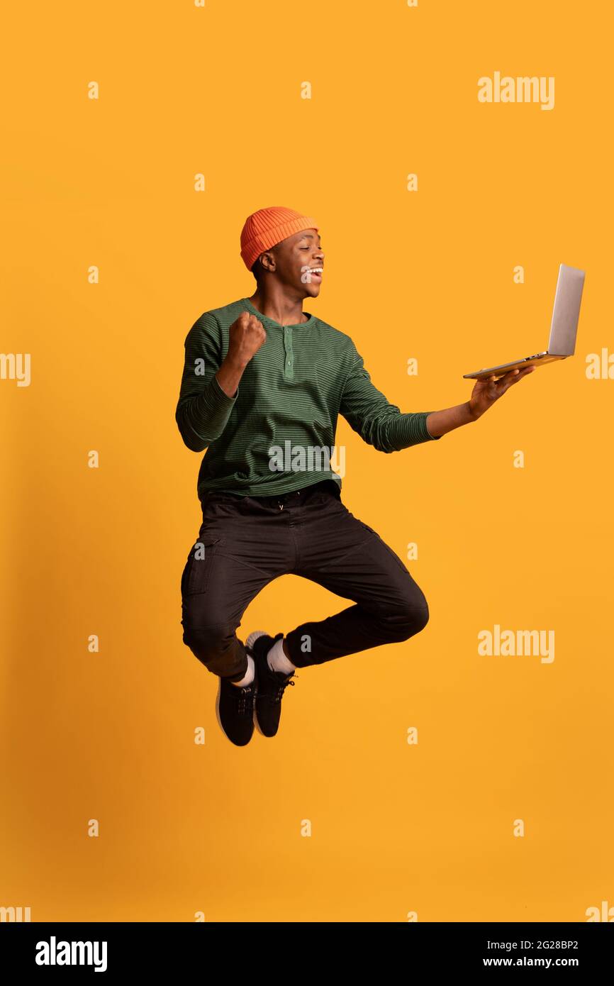 Online Win. Excited Happy Black Guy Jumping Up With Laptop Computer ...