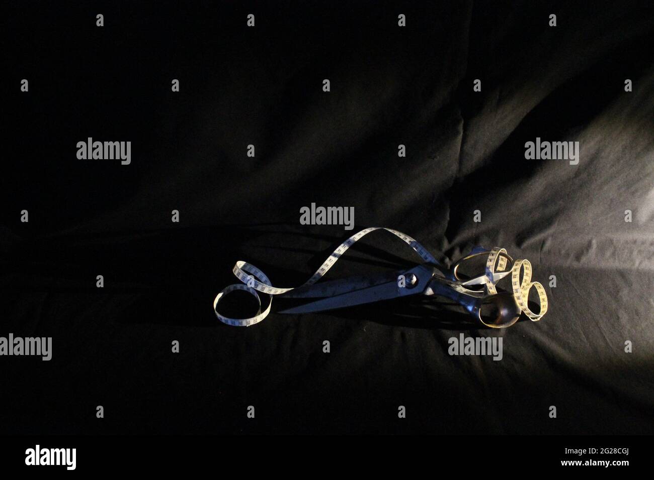 classic tailor scissors and tape measure on black background Stock ...