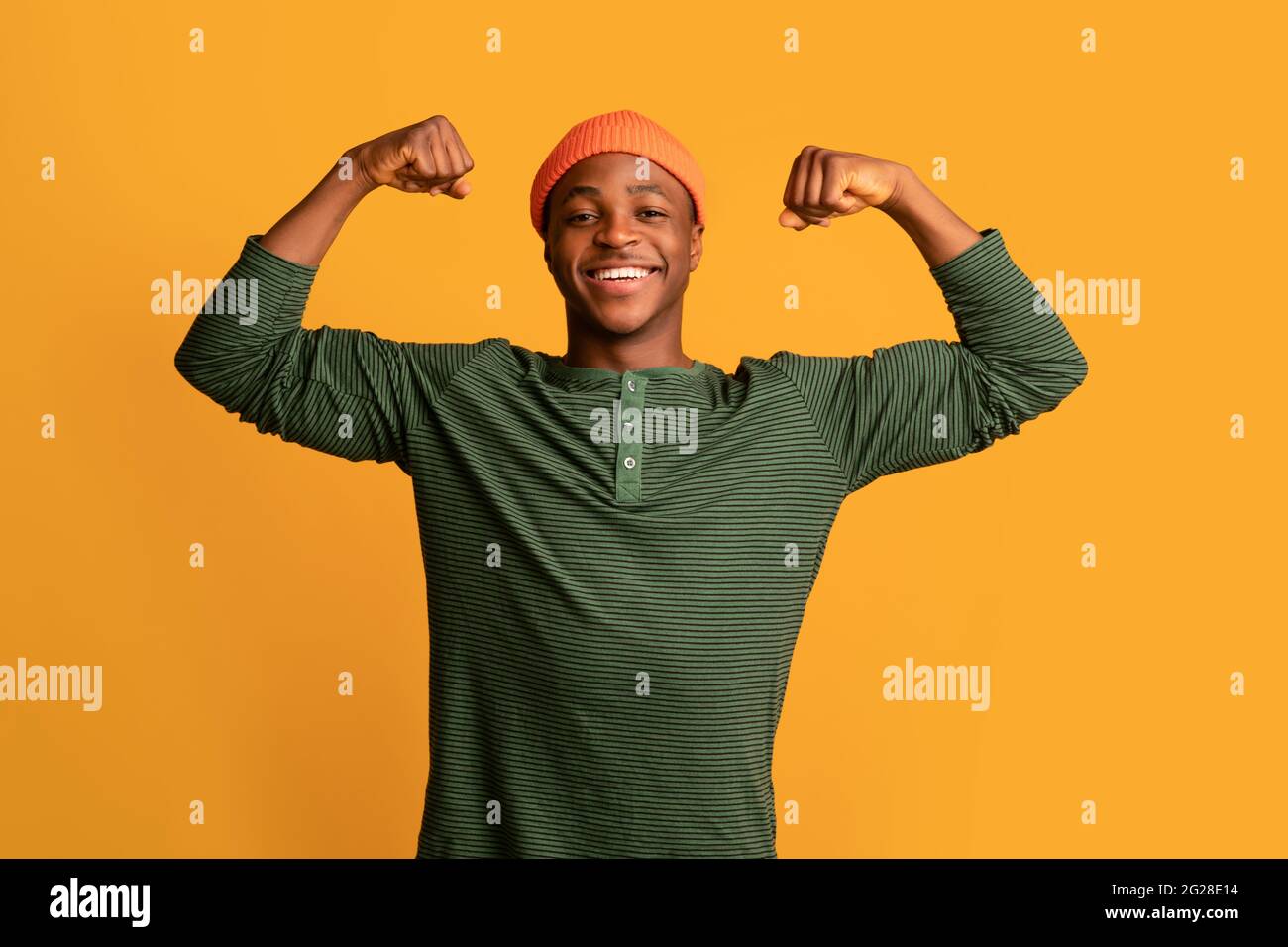 Strong Black Hipster Guy In Orange Hat Showing Biceps Muscles At Camera ...