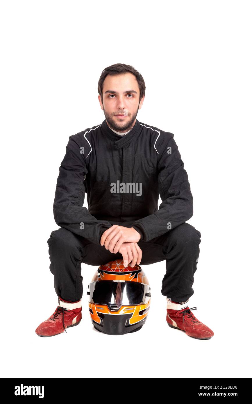 Racing driver in full gear seating in his helmet isolated in a white ...