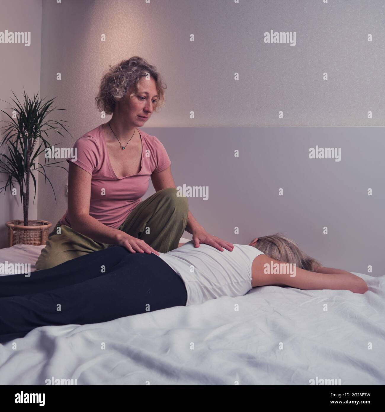 A Woman Does A Holistic Back Massage On A Home Bed In The Bedroom Blonde Masseuse On The Couch