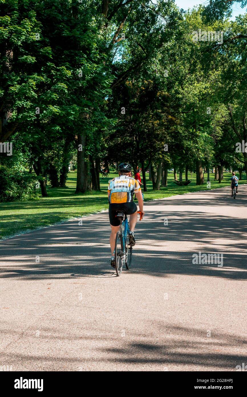 Bicyclist riding down a park path Stock Photo - Alamy