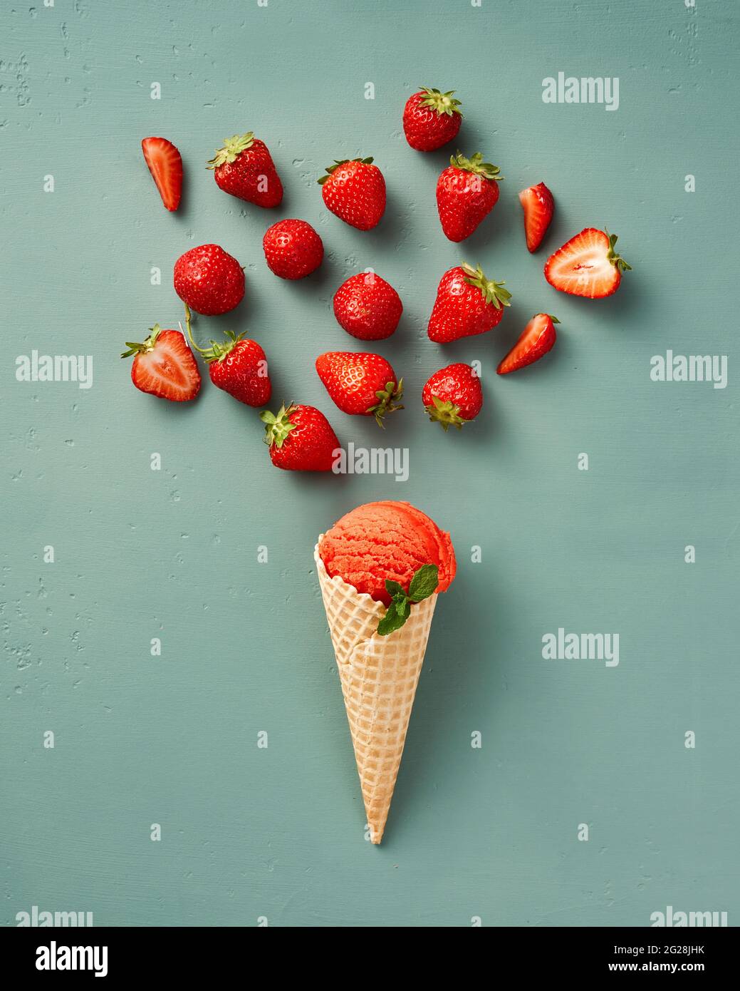 Fresh strawberry ice in cone with strawberries on blue background. Top ...