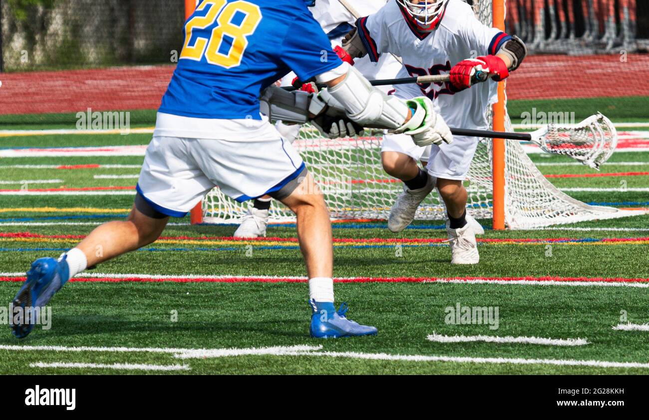 A high schhol boy lacrosse player taking a shot on goal during a game ...
