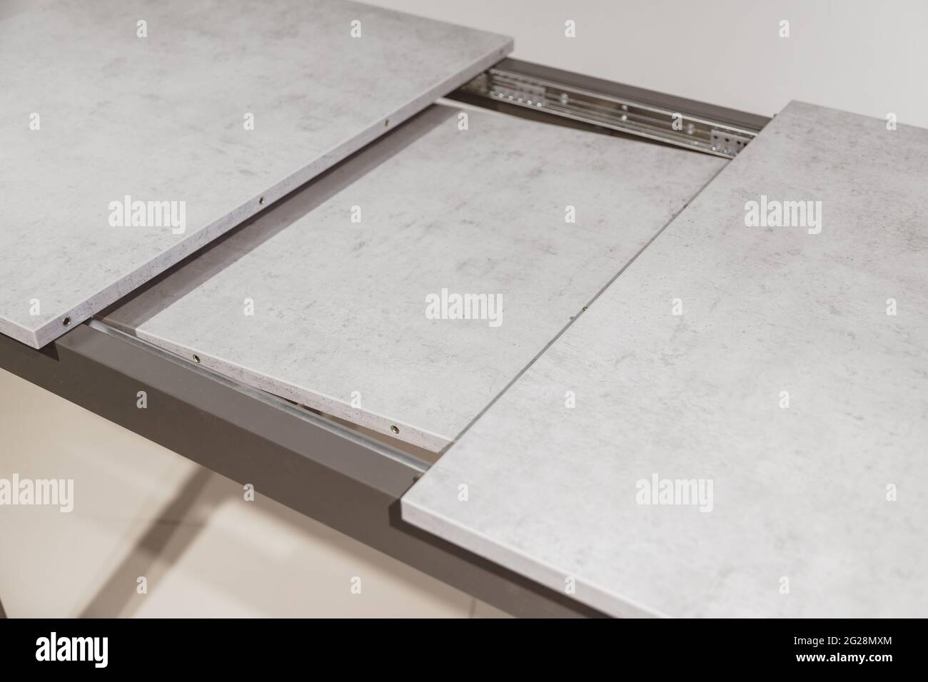 Extendable dinning table made of chipboard. Slide gear close up view ...