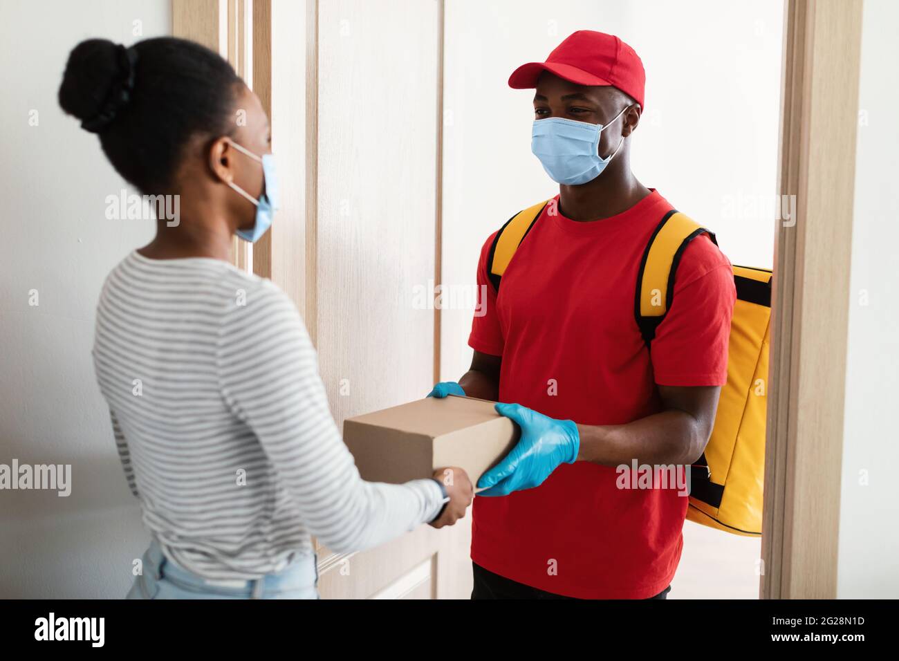 Courier Wearing Face Mask Giving Package Box To Lady Indoor Stock Photo ...
