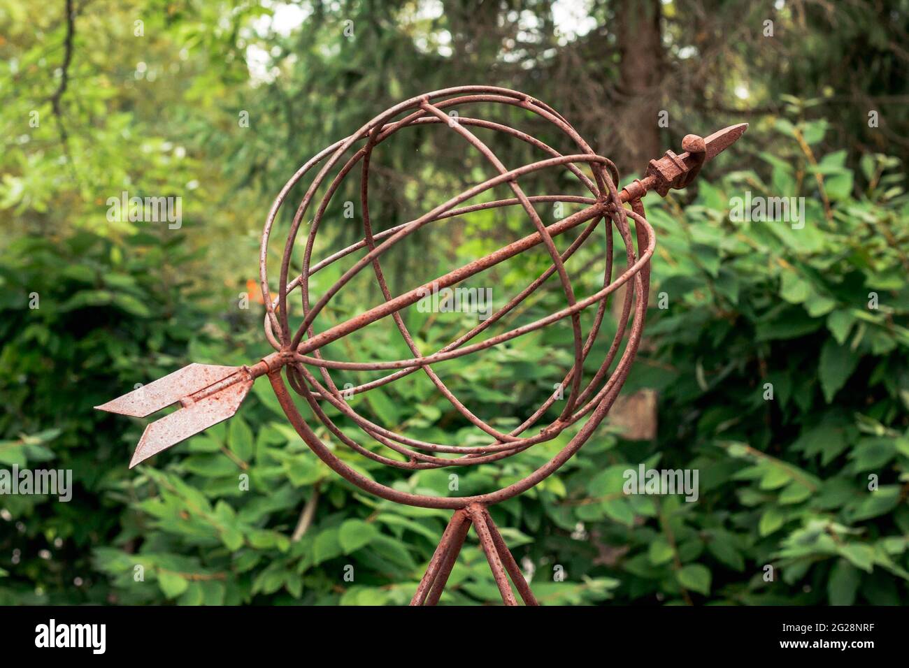 Close up of an arrow flying through a globe statue Stock Photo - Alamy