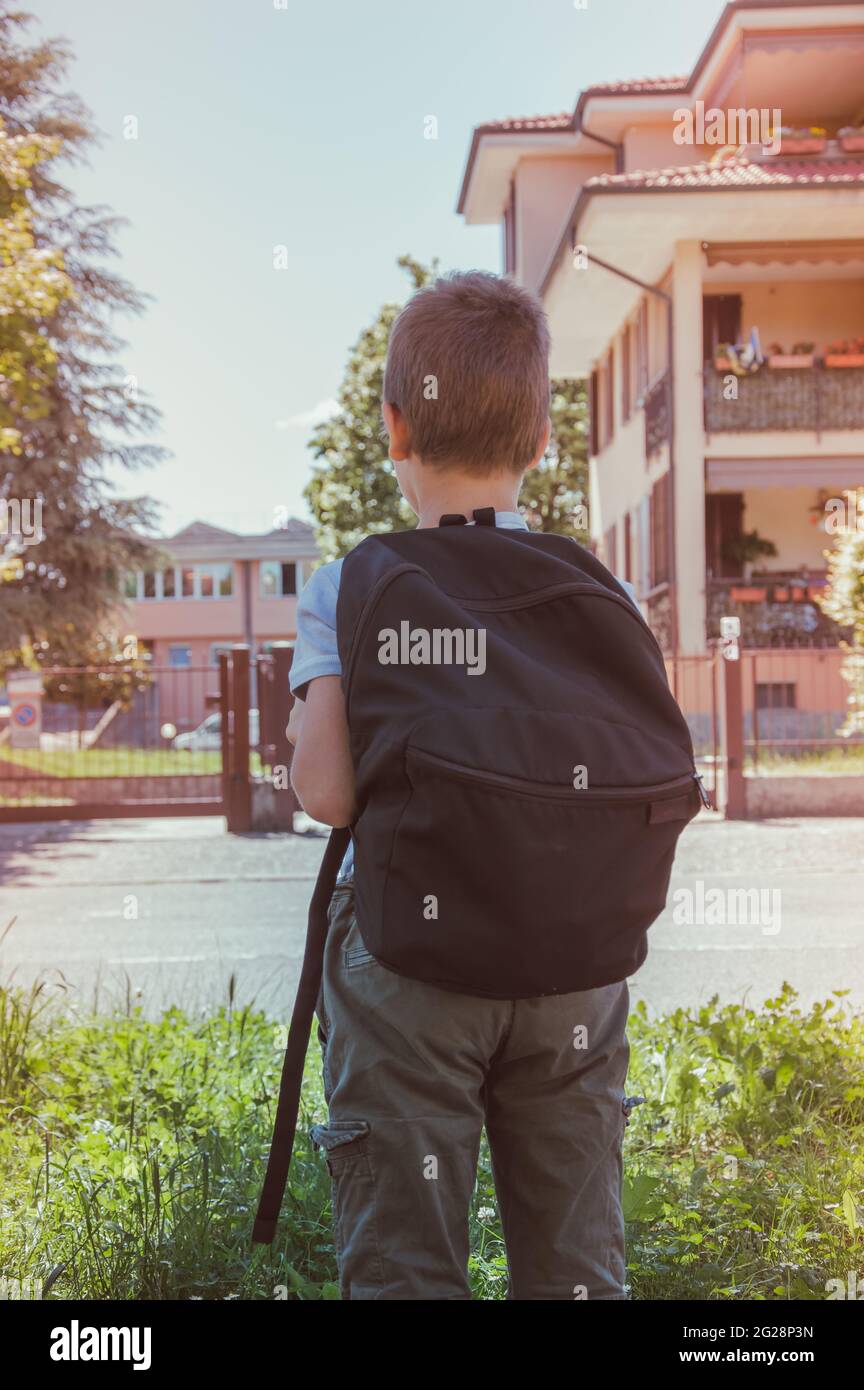 schoolboy comes back to school. Behind shoulders at the pupil a satchel ...