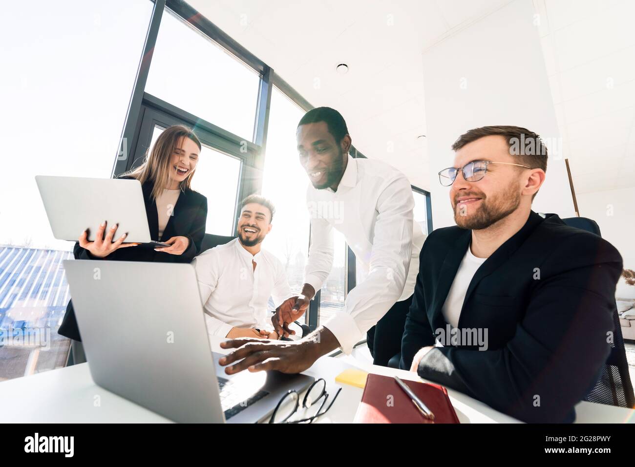 Happy office employee working together on laptop Stock Photo - Alamy
