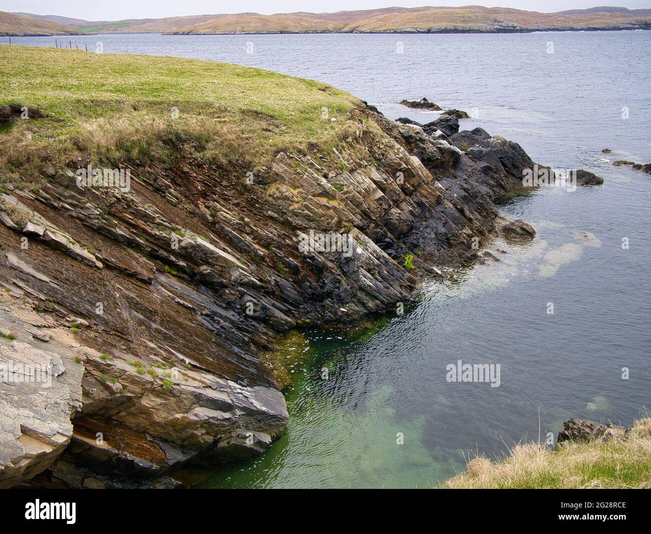 Inclined rock strata on coastal cliffs on the Ness of Hillswick ...