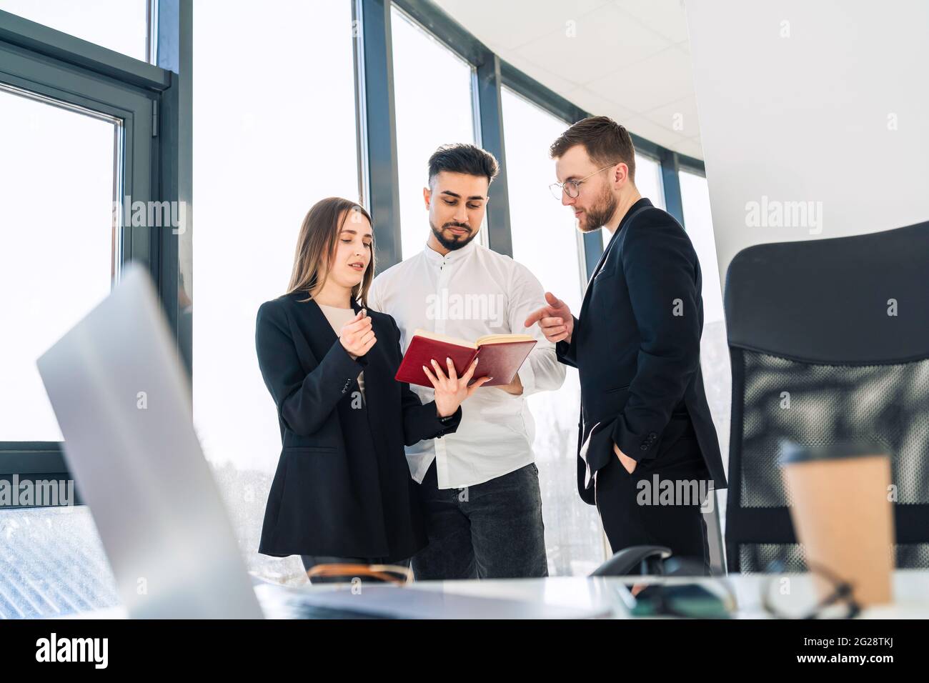 Three business people are standing in the office Stock Photo - Alamy