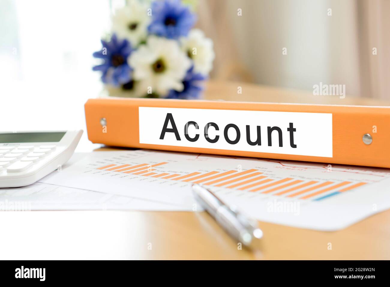 Orange binder account on desk in the office with calculator and pen ...