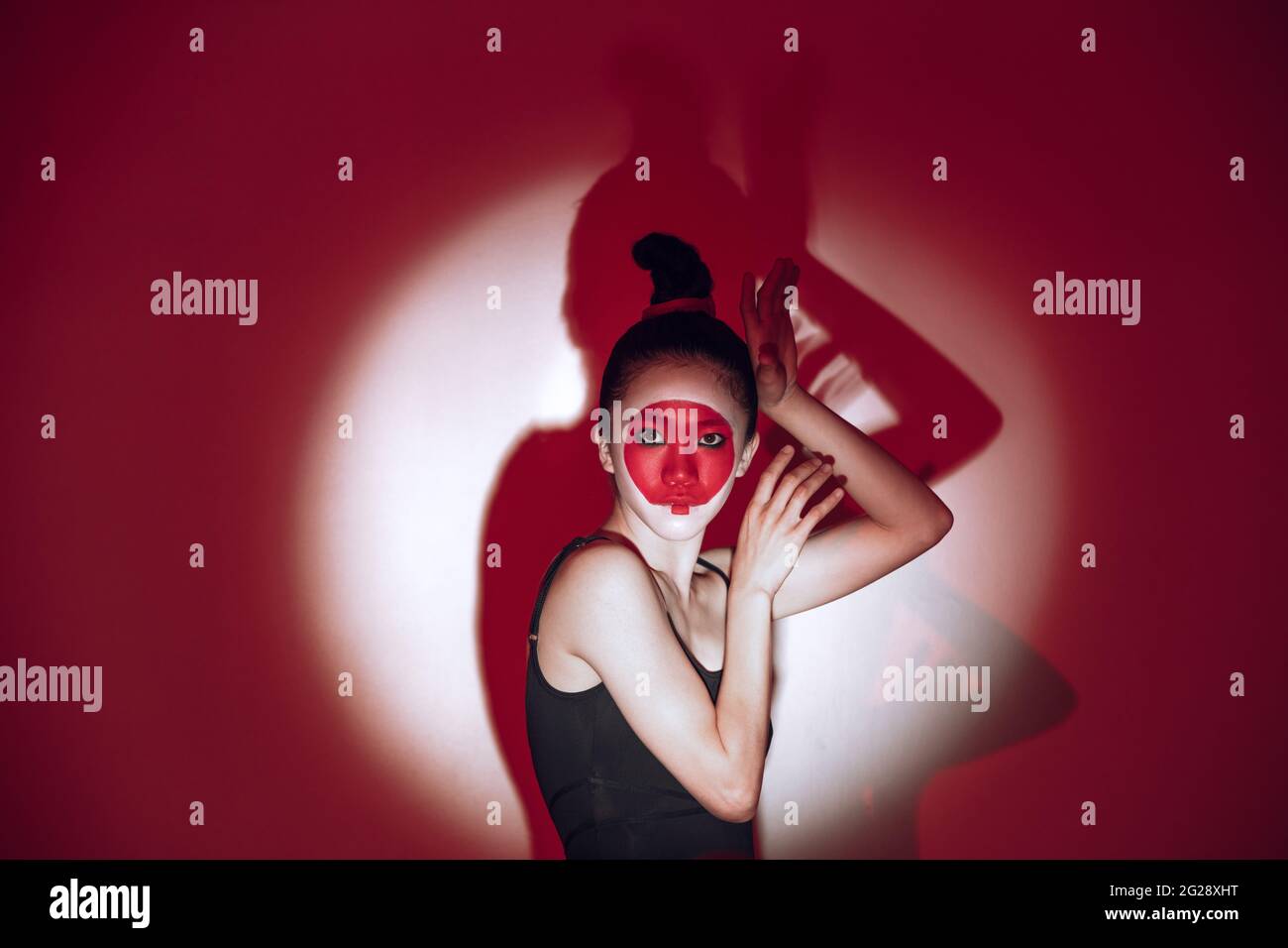 Ballet dancer dancing over red studio background. Modern design ...