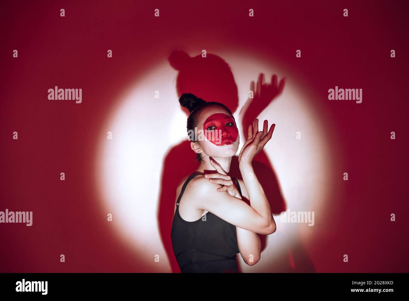 Ballet dancer dancing over red studio background. Modern design ...