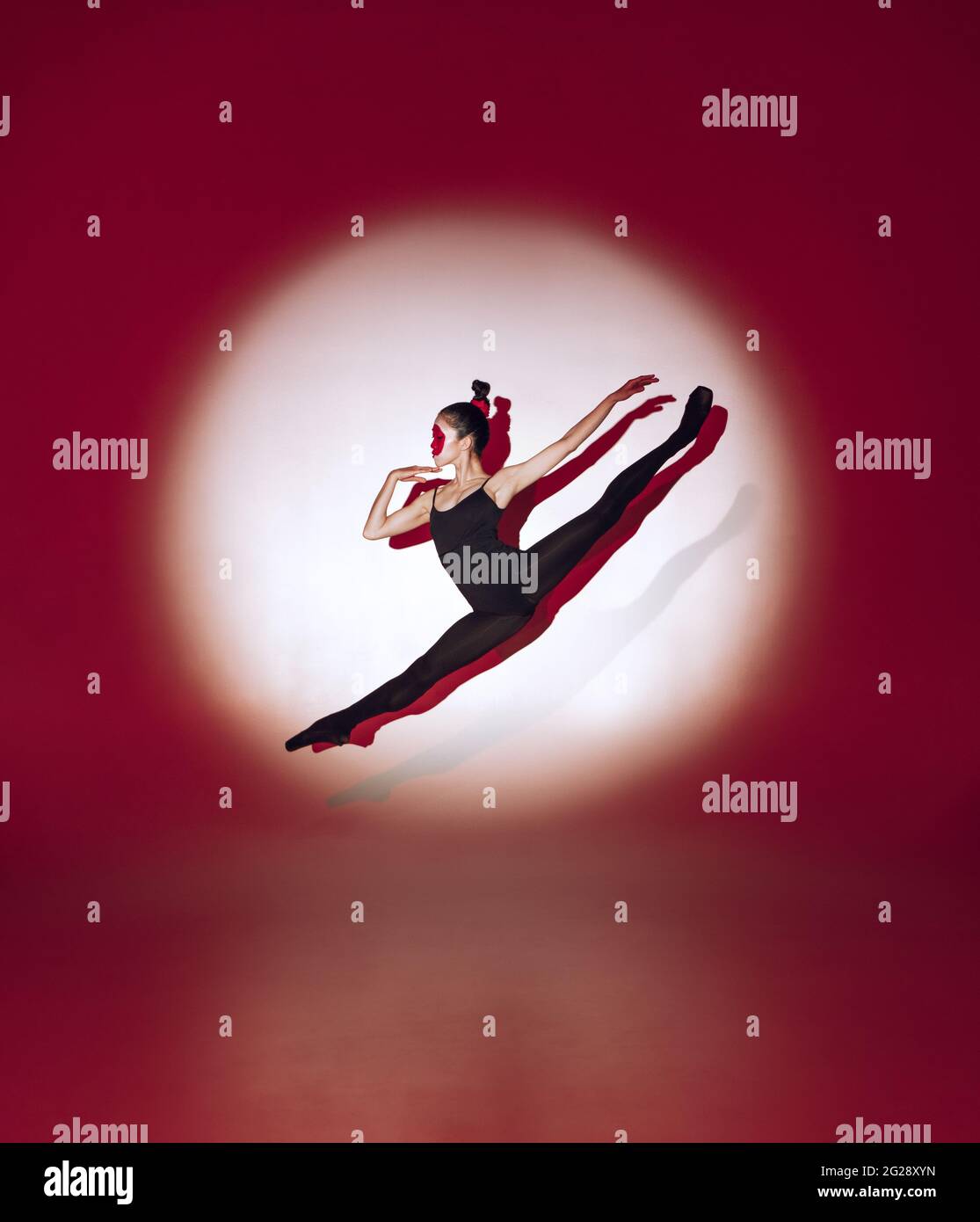 Ballet dancer dancing over red studio background. Modern design ...
