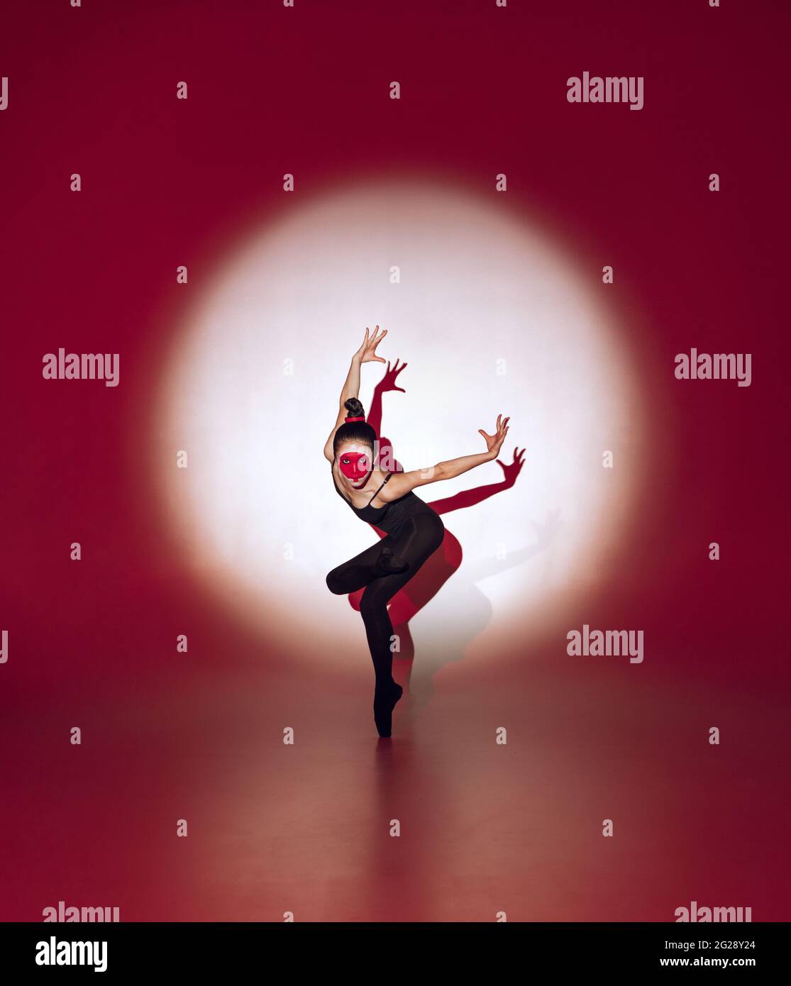 Ballet dancer dancing over red studio background. Modern design ...