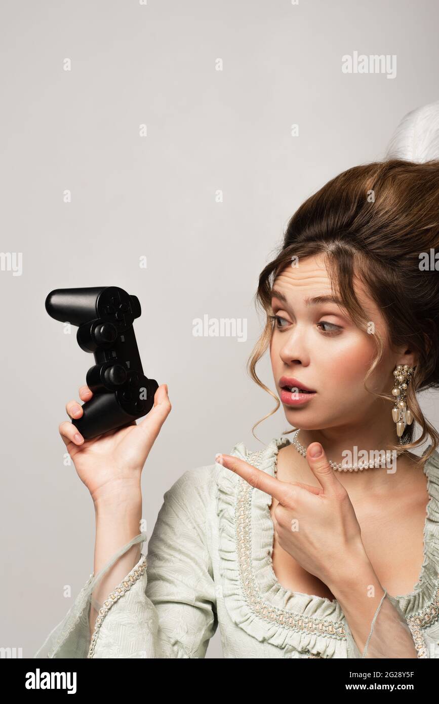 KYIV, UKRAINE - APRIL 22, 2021: retro style woman pointing at joystick ...