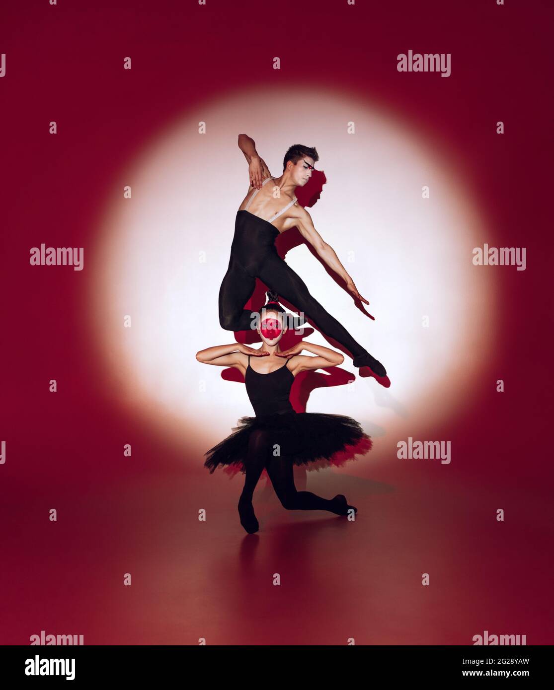 Ballet dancers dancing over red studio background. Modern design ...