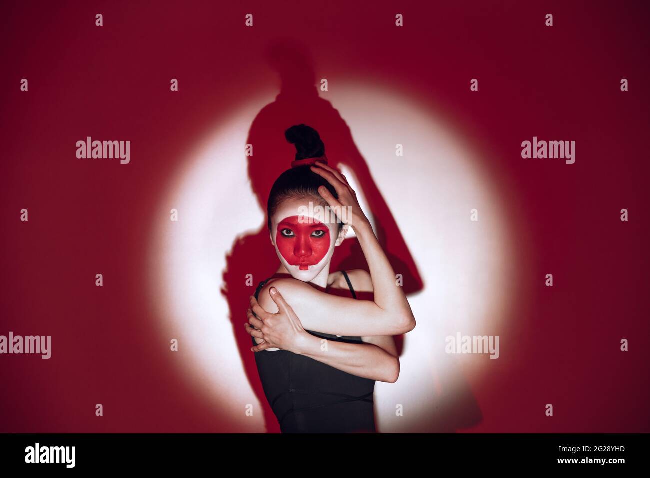 Ballet dancer dancing over red studio background. Modern design ...