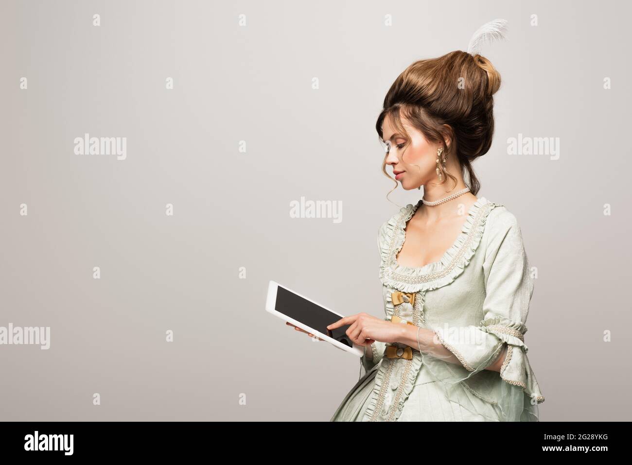 young woman in vintage dress using digital tablet with blank screen ...