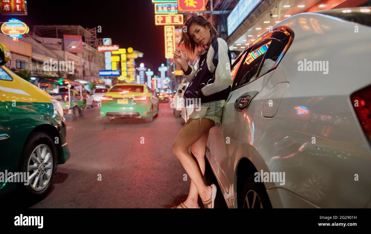 Super model dark hair wearing a tour jacket on Yaowarat Road Samphanthawong District Chinatown ...