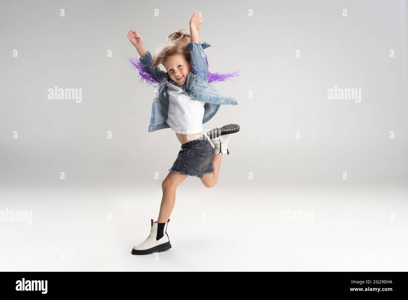 Smiling cute girl running over white studio background. Caucasian model ...