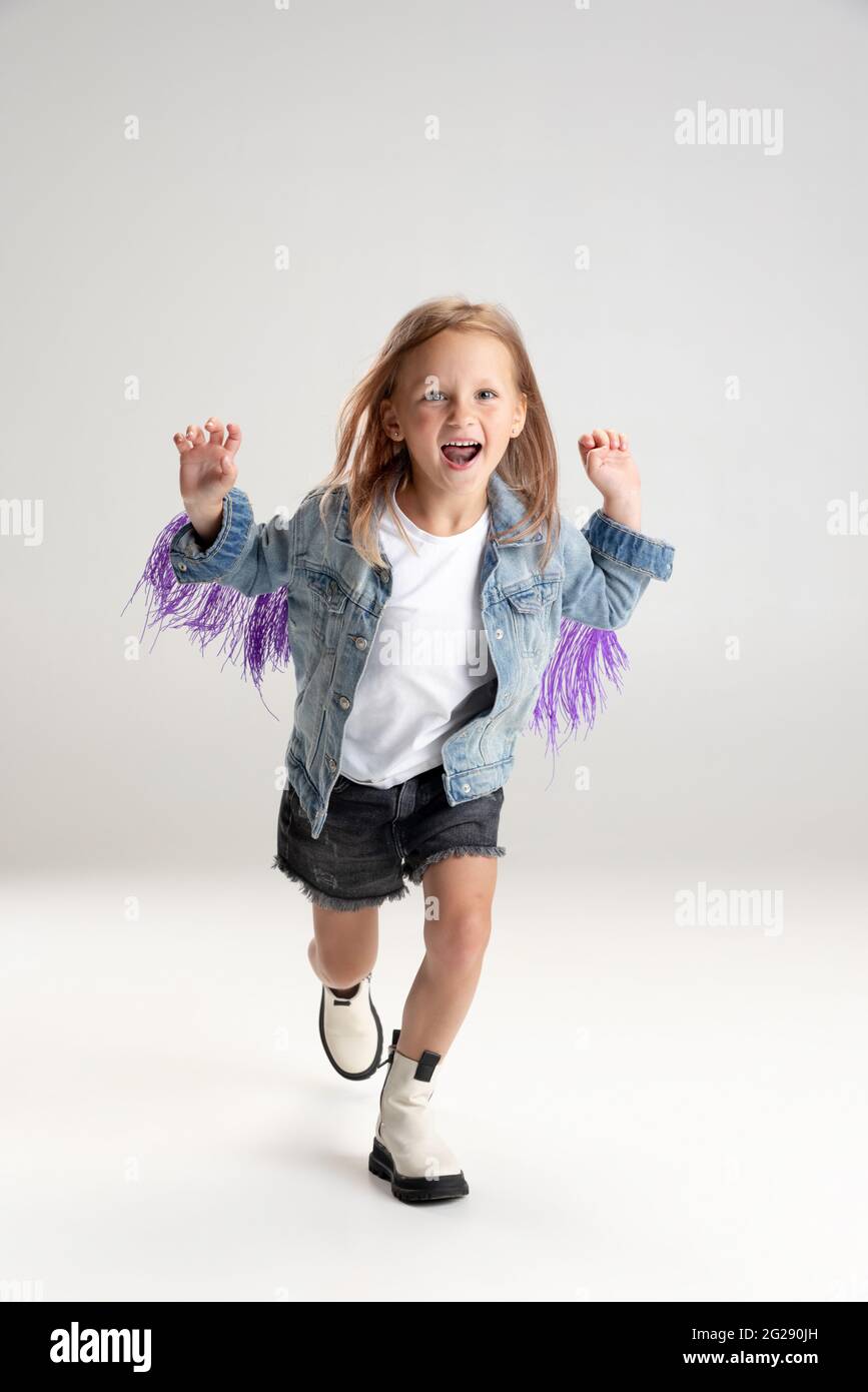 Smiling cute girl running over white studio background. Caucasian model ...