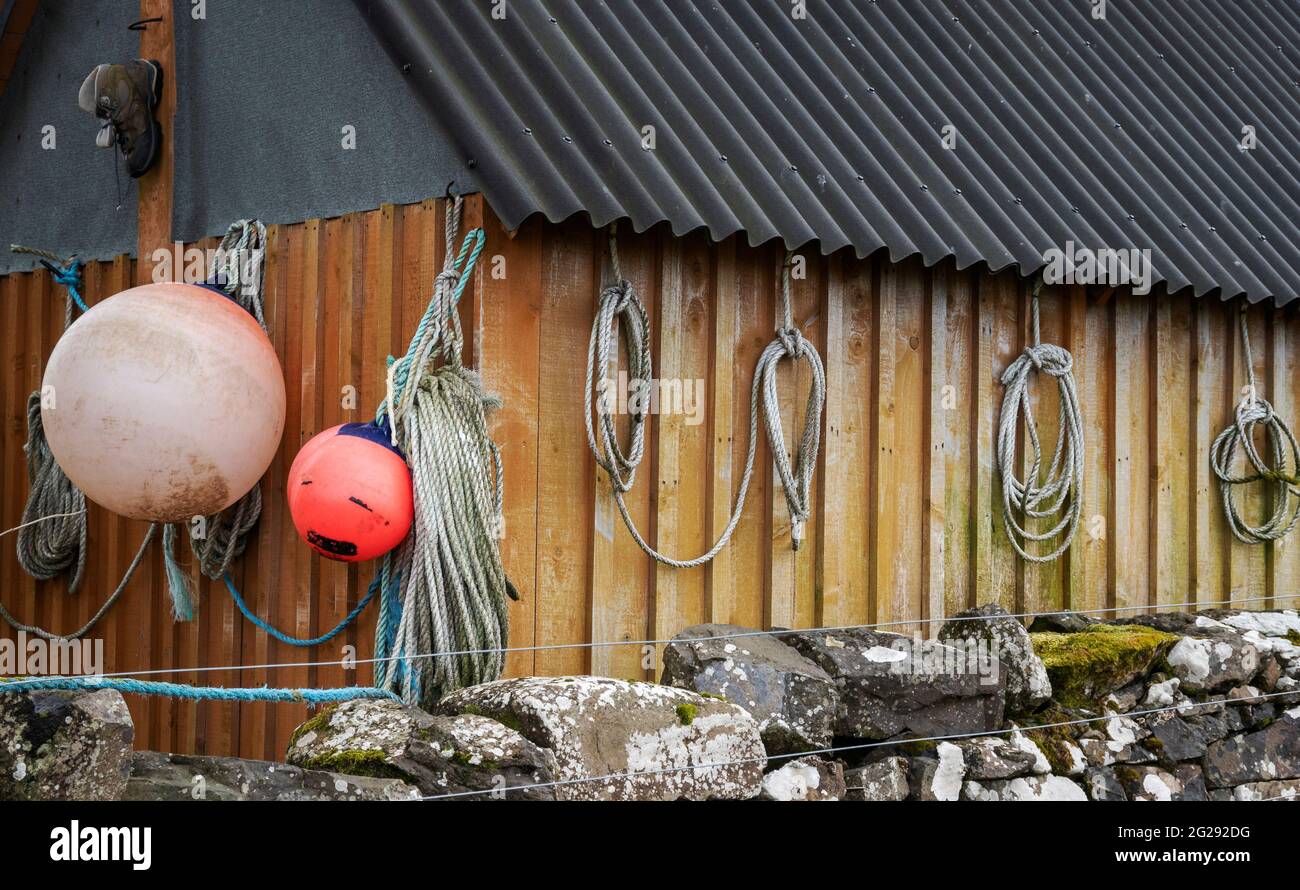 A selection of ropes and buoys hung on a shed at Croig Harbour on the ...