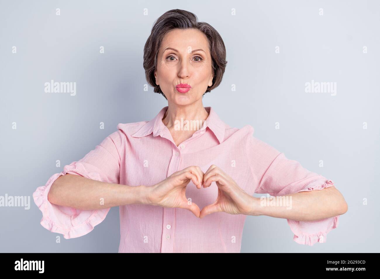 Portrait of attractive affectionate woman showing heart shape sending ...