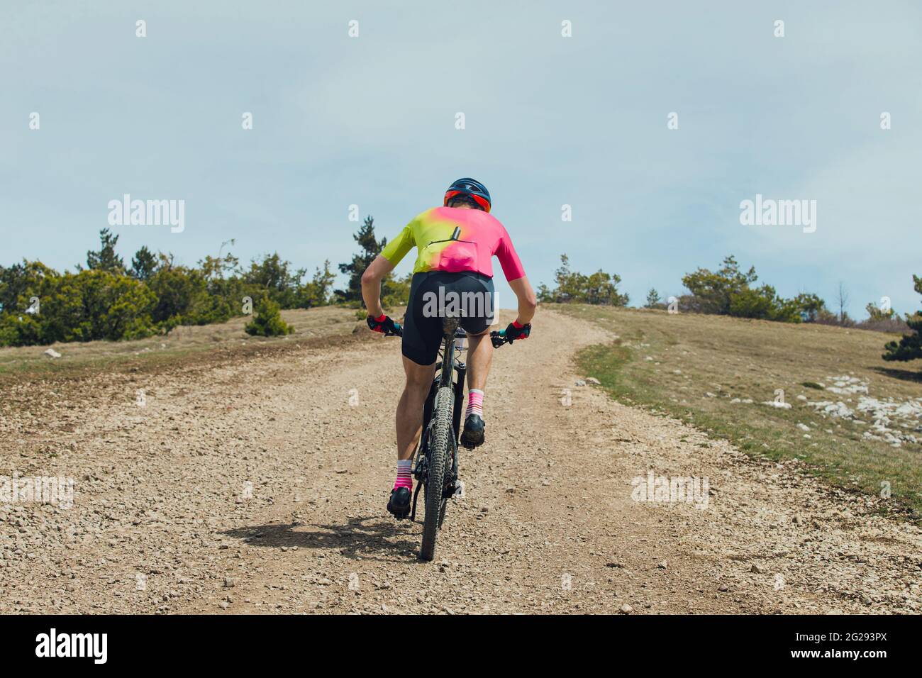 back male athlete on mountain bike riding uphill on trail Stock Photo ...