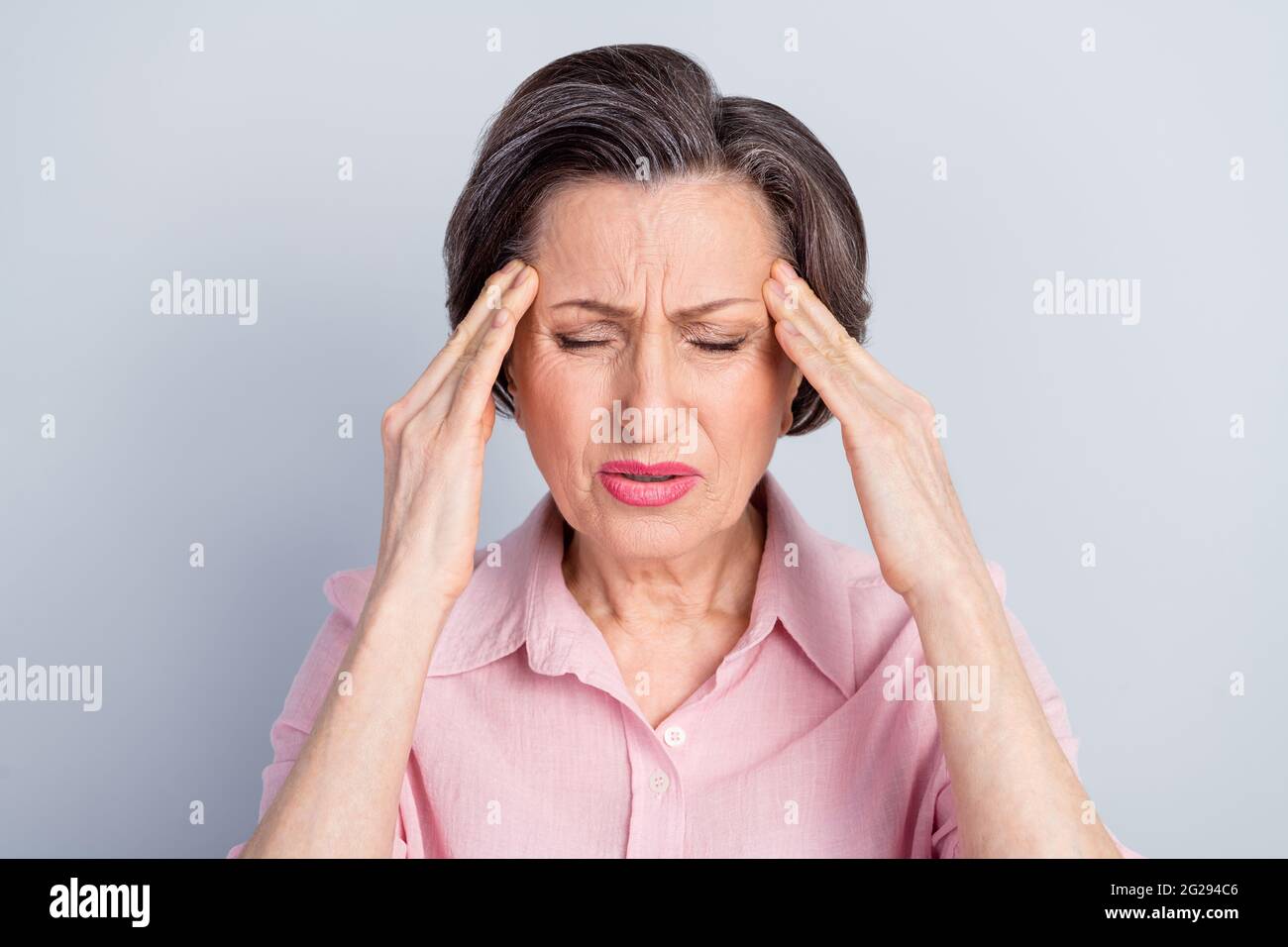 Photo of unhappy upset old woman hold hands head temples headache bad moos isolated on grey ...