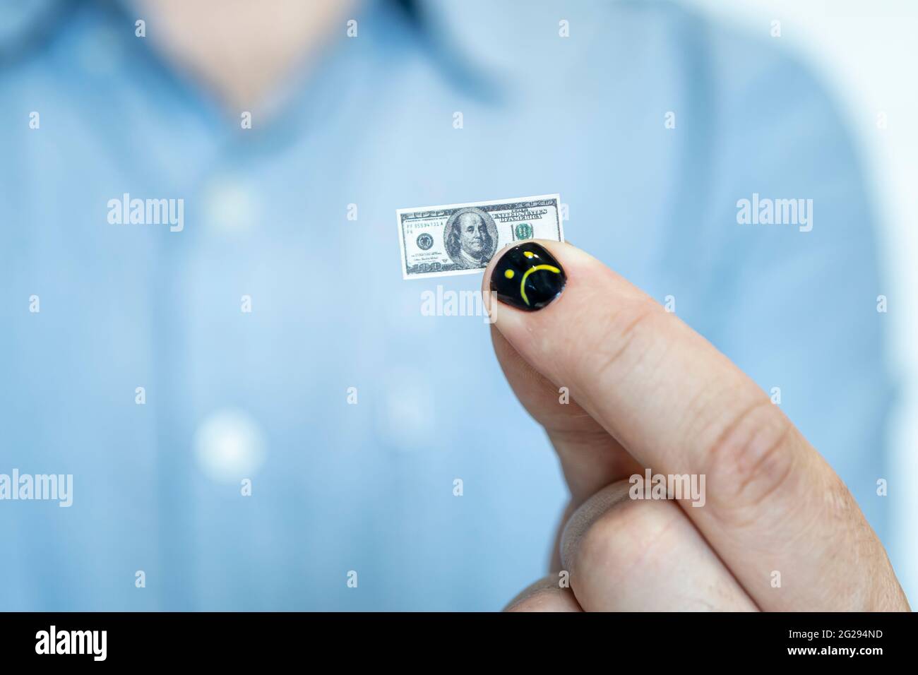 Hand holding miniature dollar note. the concept of dollar inflation. a ...