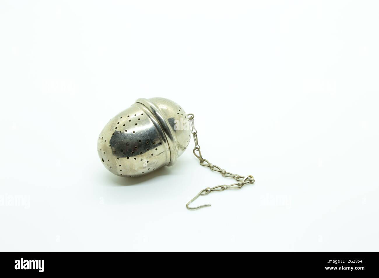 A shiny old steel tea sifter with chain and hook Stock Photo - Alamy