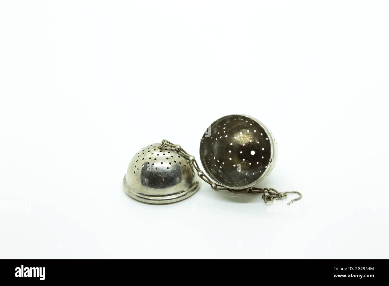 A shiny old steel tea sifter with chain and hook in two parts Stock ...