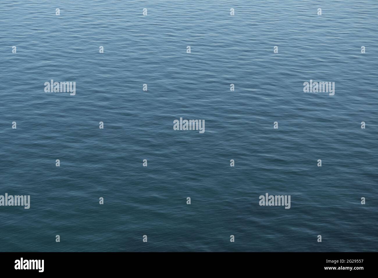 Calm sea with blue waves waving in summer Stock Photo - Alamy