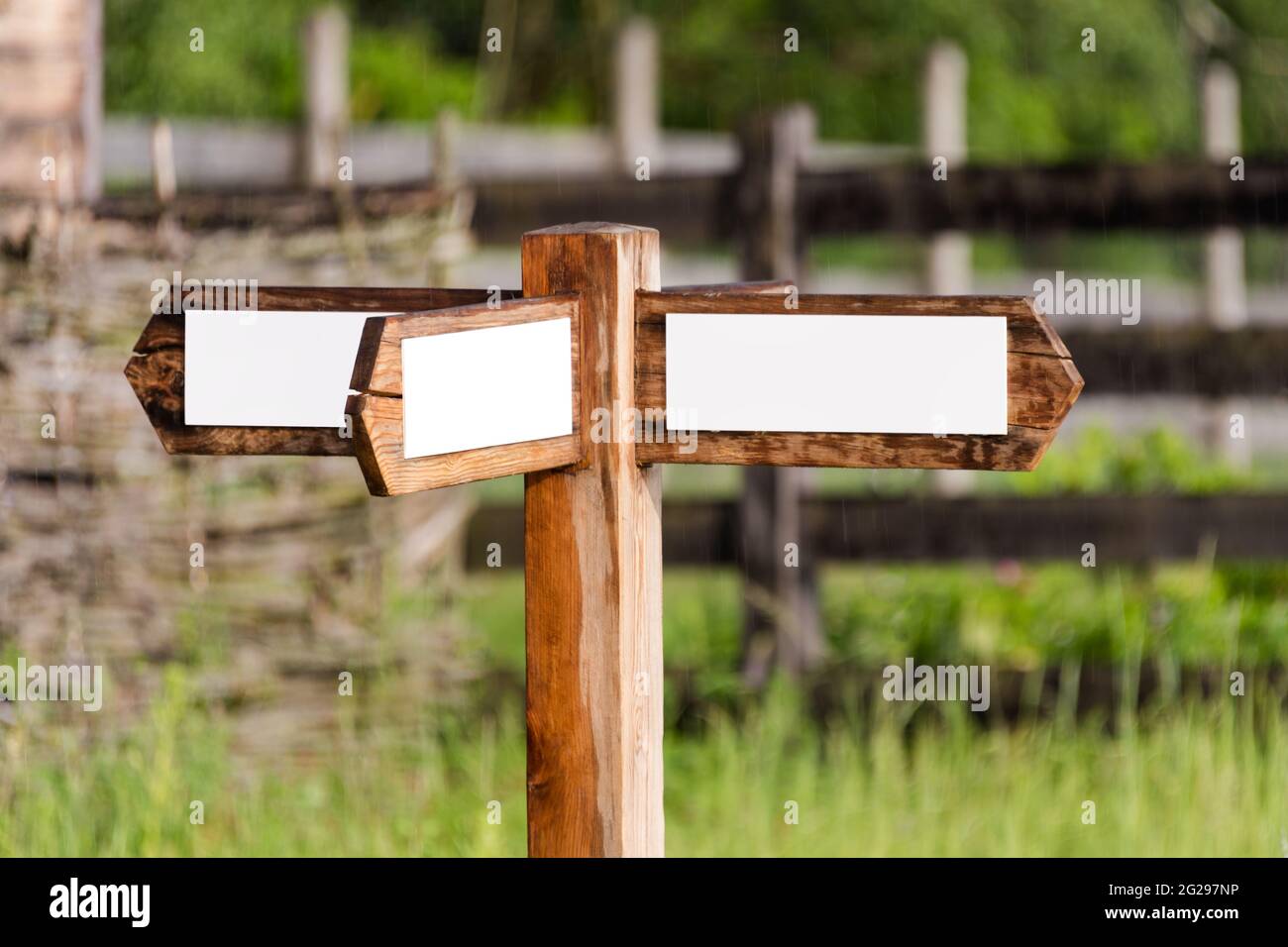 Empty wooden sign with arrows on the ranch. Simple wooden triple ...