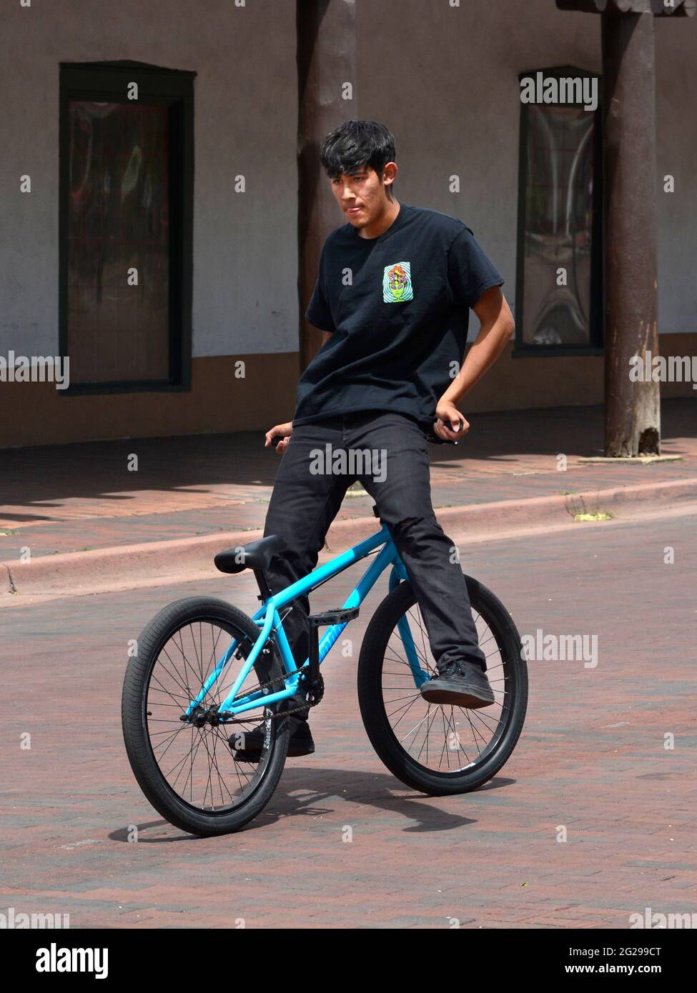 A young attempts to ride his bicycle backwards in Santa Fe, New Mexico ...