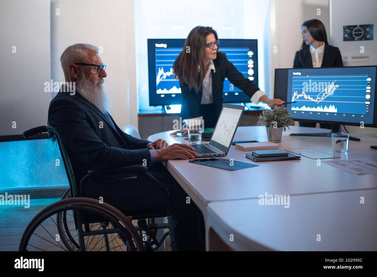 Group of colleagues discussing project with diagrams on computers Stock ...