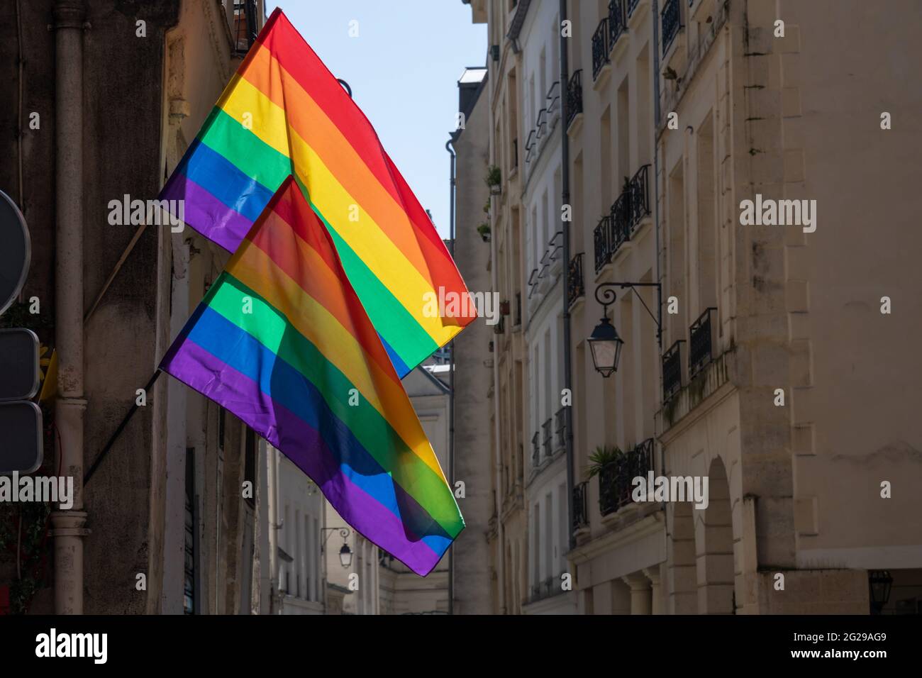 Two Lgbtq flags hanging at antique building corner during Paris pride ...