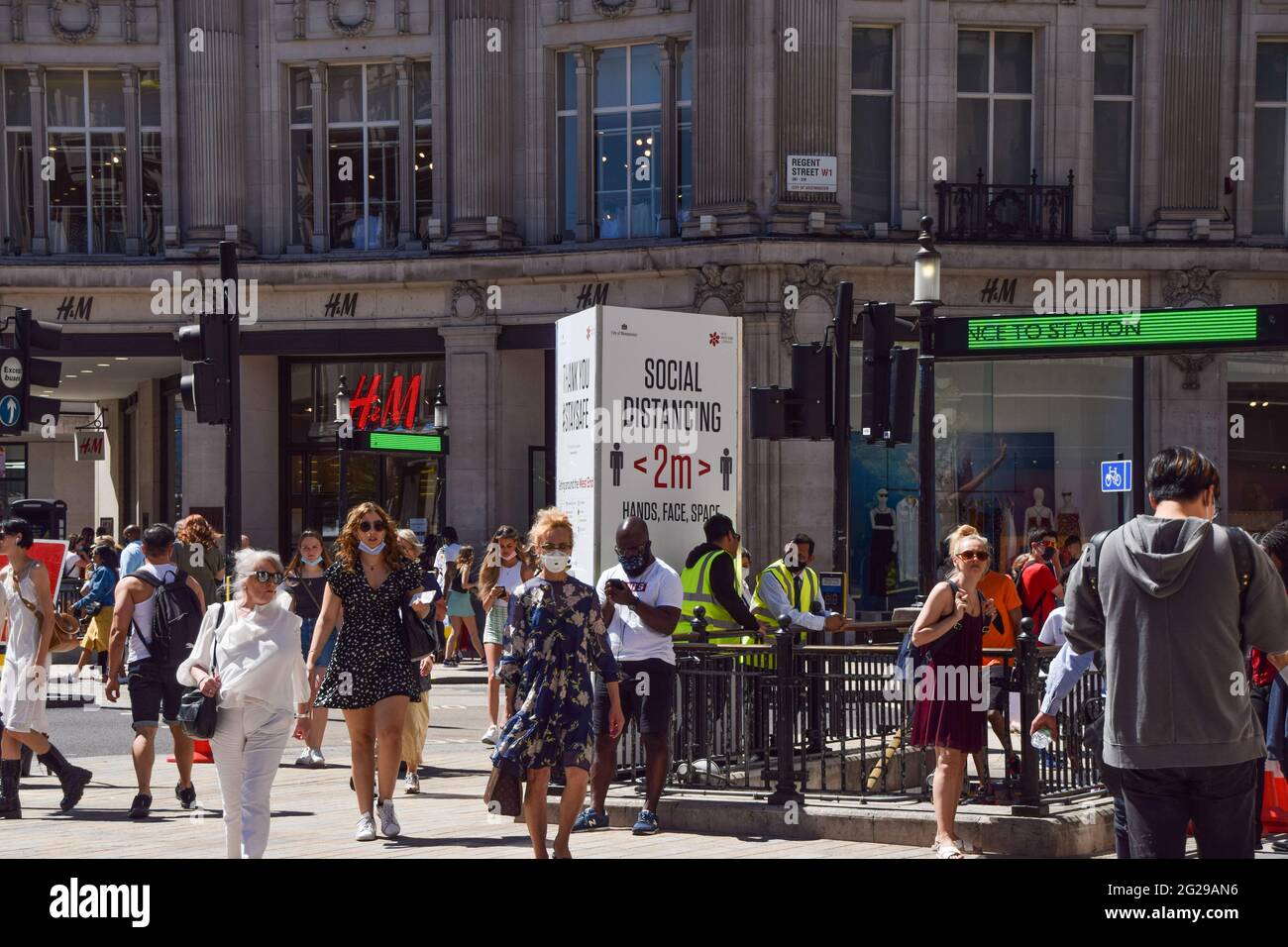 London, UK. 09th June, 2021. People walk past a Social Distancing sign ...