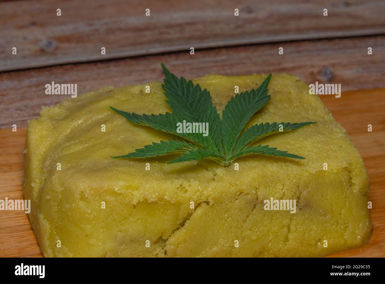 Marijuana butter on wooden table with dark green leafs Stock Photo - Alamy