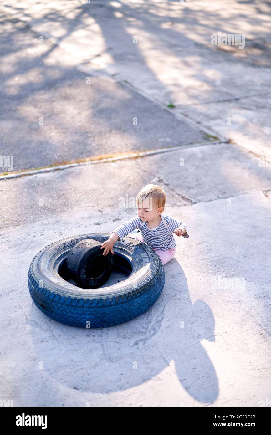 Child plays with a car tire in the parking lot. View from above Stock ...