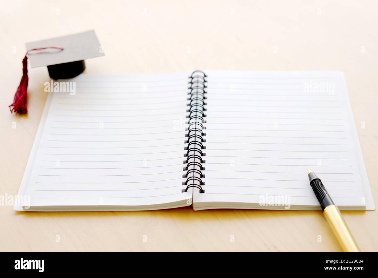 Blank notebook on the table and graduation cap Stock Photo - Alamy