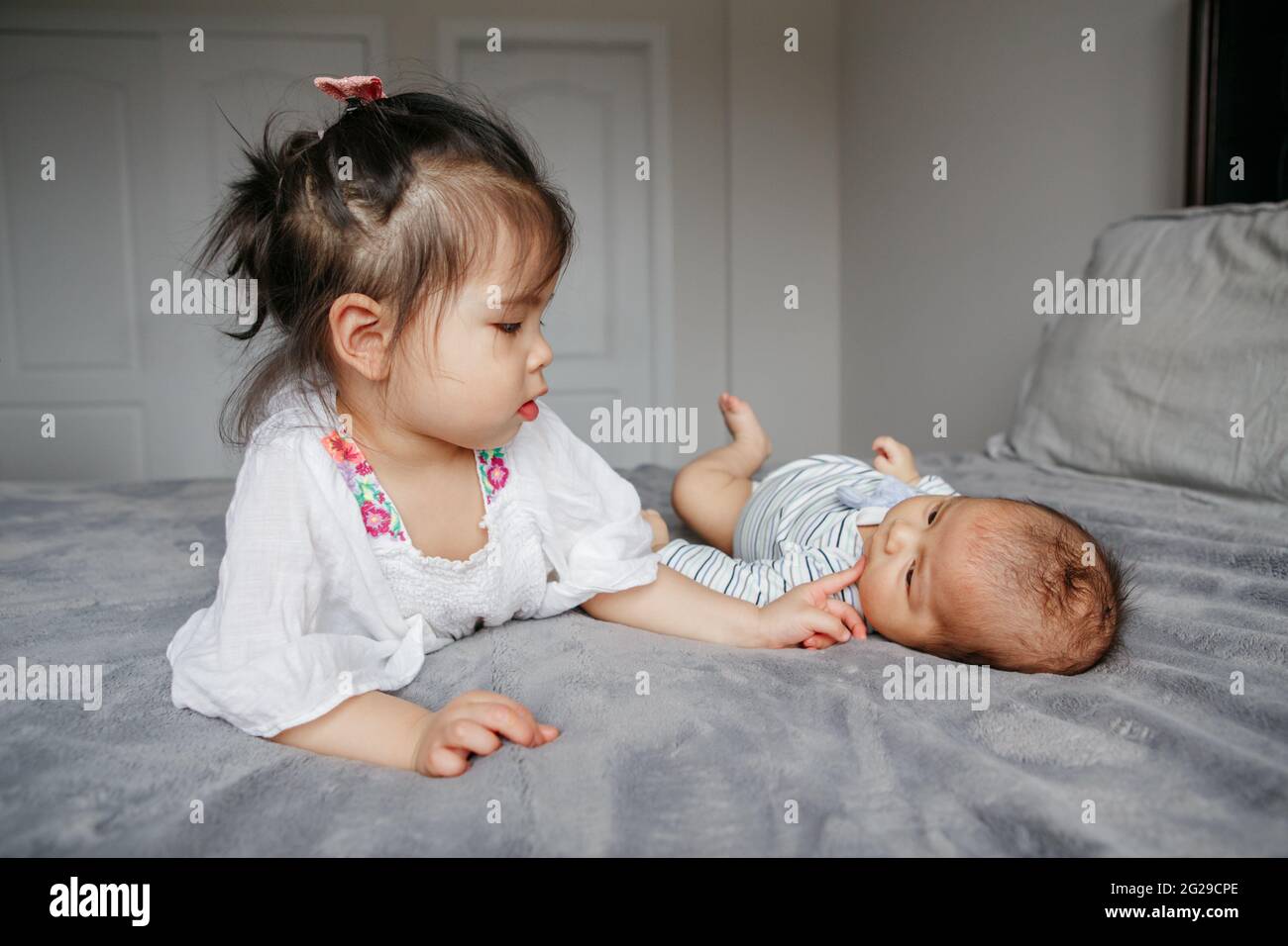 Cute Asian Chinese girl touching little newborn baby brother Stock ...