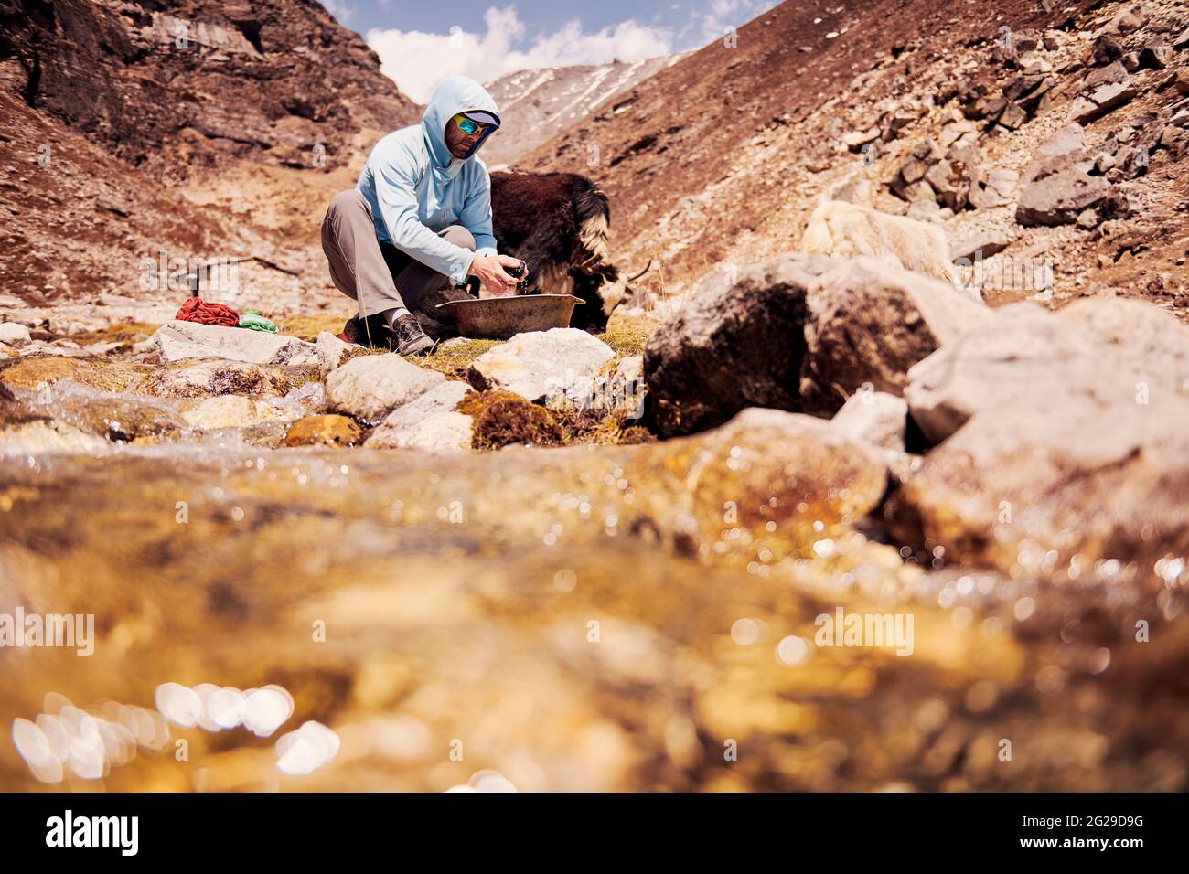 Trekker washing his clothes by the stream in Nepal Stock Photo - Alamy